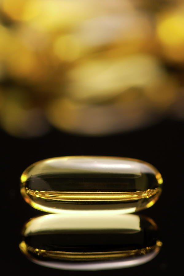 Cod Liver Oil Capsule by Paul Whitehill / Science Photo Library