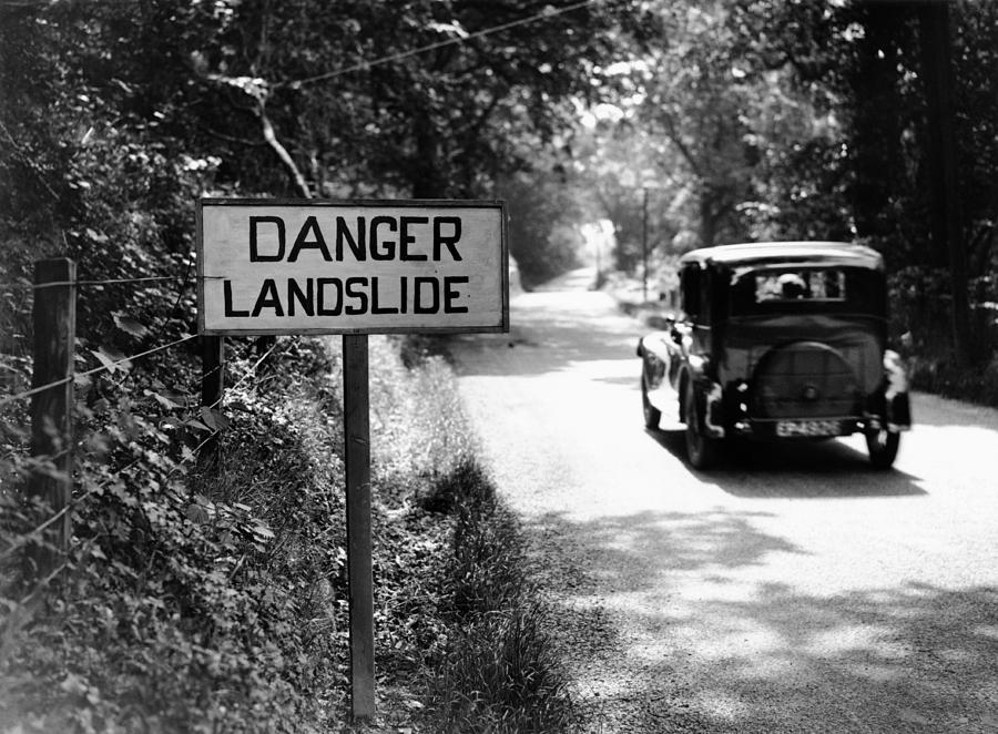 Car Passing Danger Landslide Sign B&w by Hulton Archive